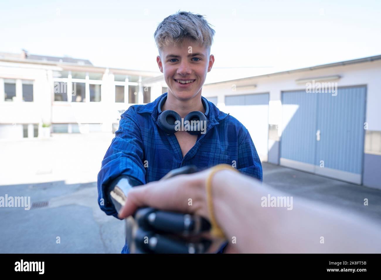 Smiling teenage boy with disability doing handshake with man Stock ...