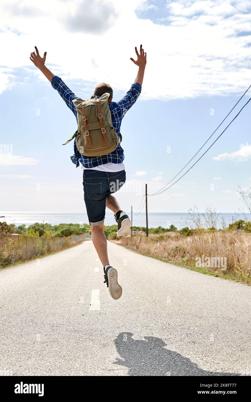 Happy man backpack raising arms hi-res stock photography and images - Alamy