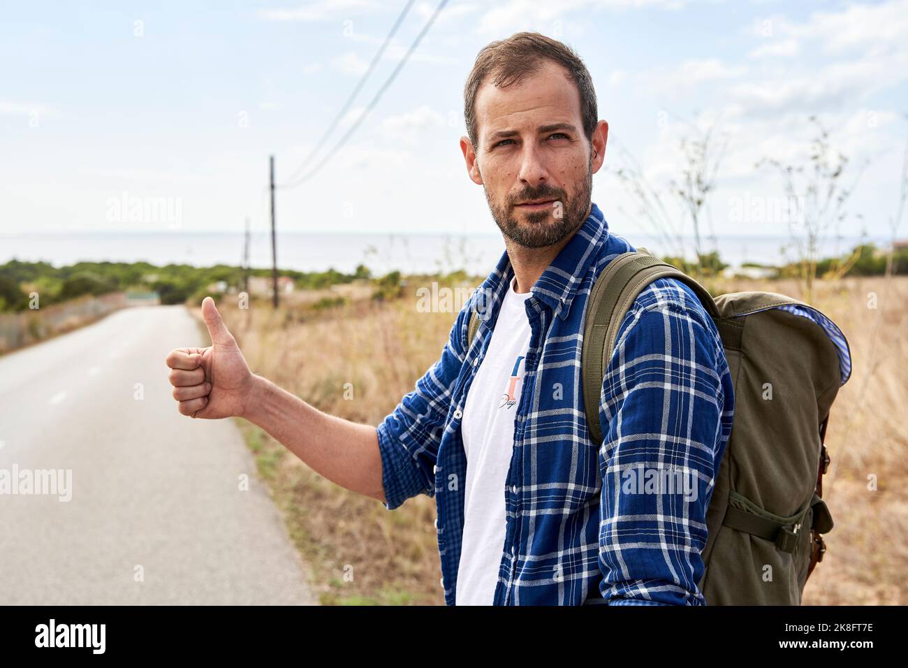 Man wearing backpack gesturing thumbs up Stock Photo - Alamy