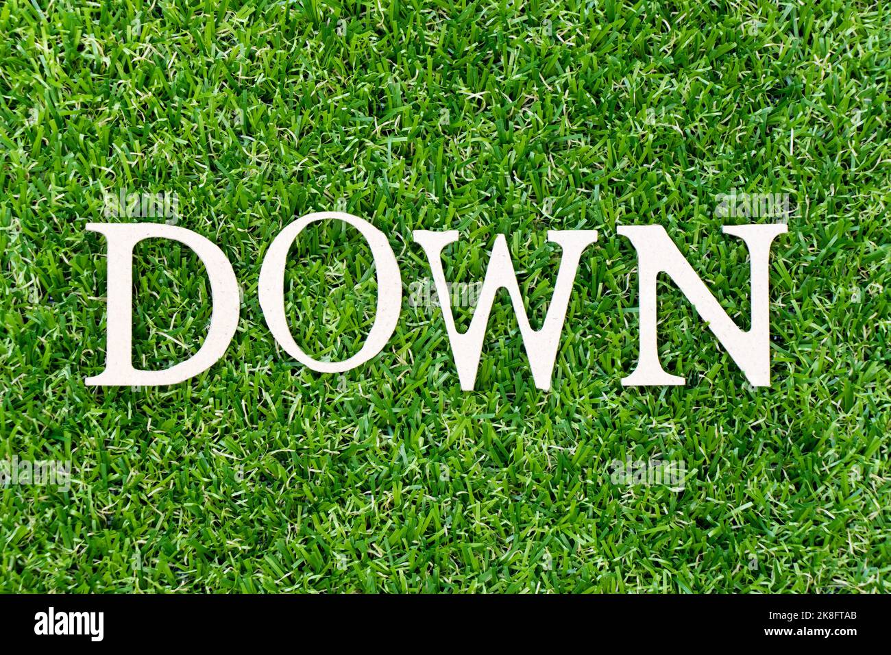 Wood letter in word down on green grass background Stock Photo - Alamy