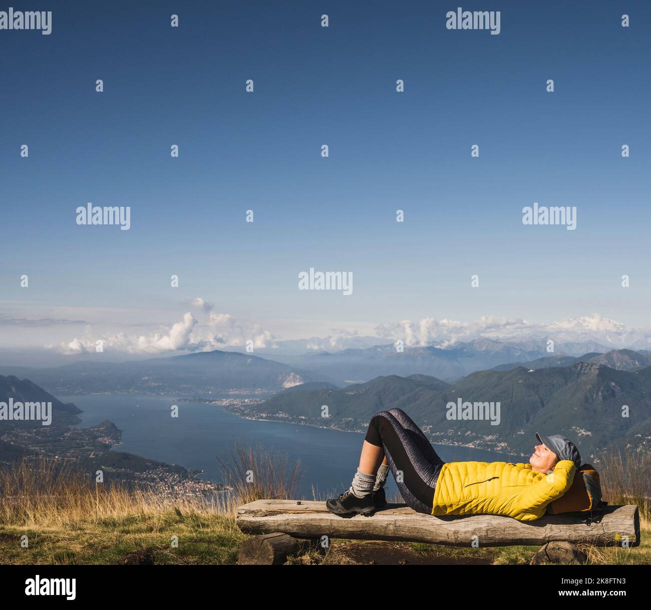 Mature woman wearing cap relaxing on bench Stock Photo - Alamy