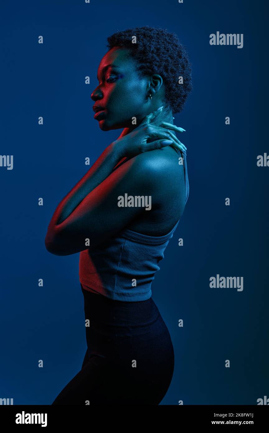 Woman standing gracefully over dark studio background Stock Photo - Alamy