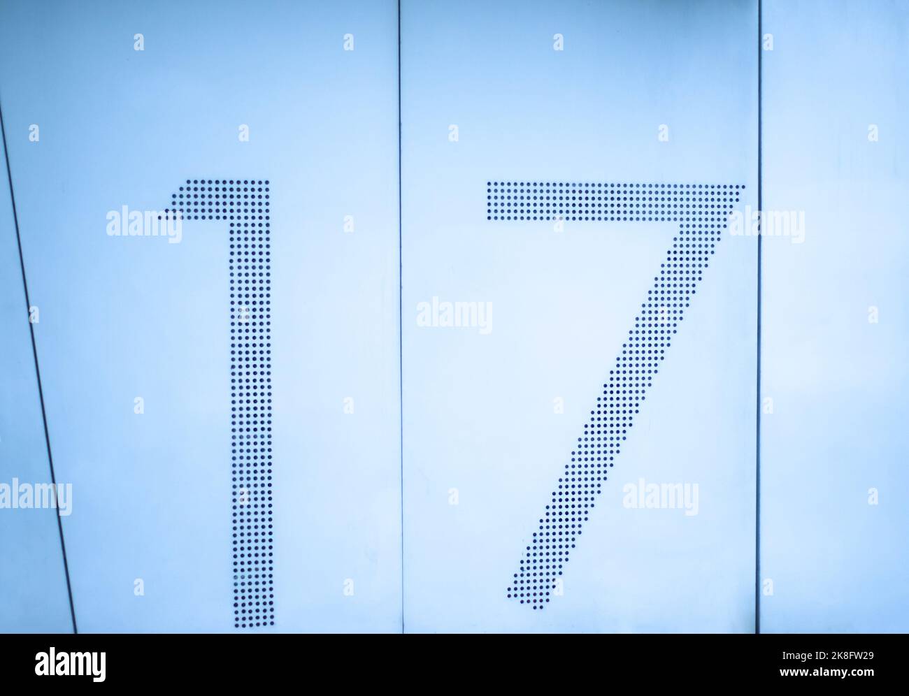 Perforated number 17. Backgrounds with numbers. Metal wall with a ...