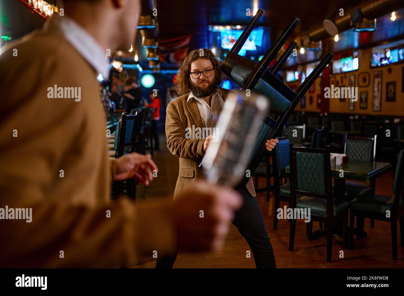Two man hooligan football team fans get in bar fight Stock Photo - Alamy