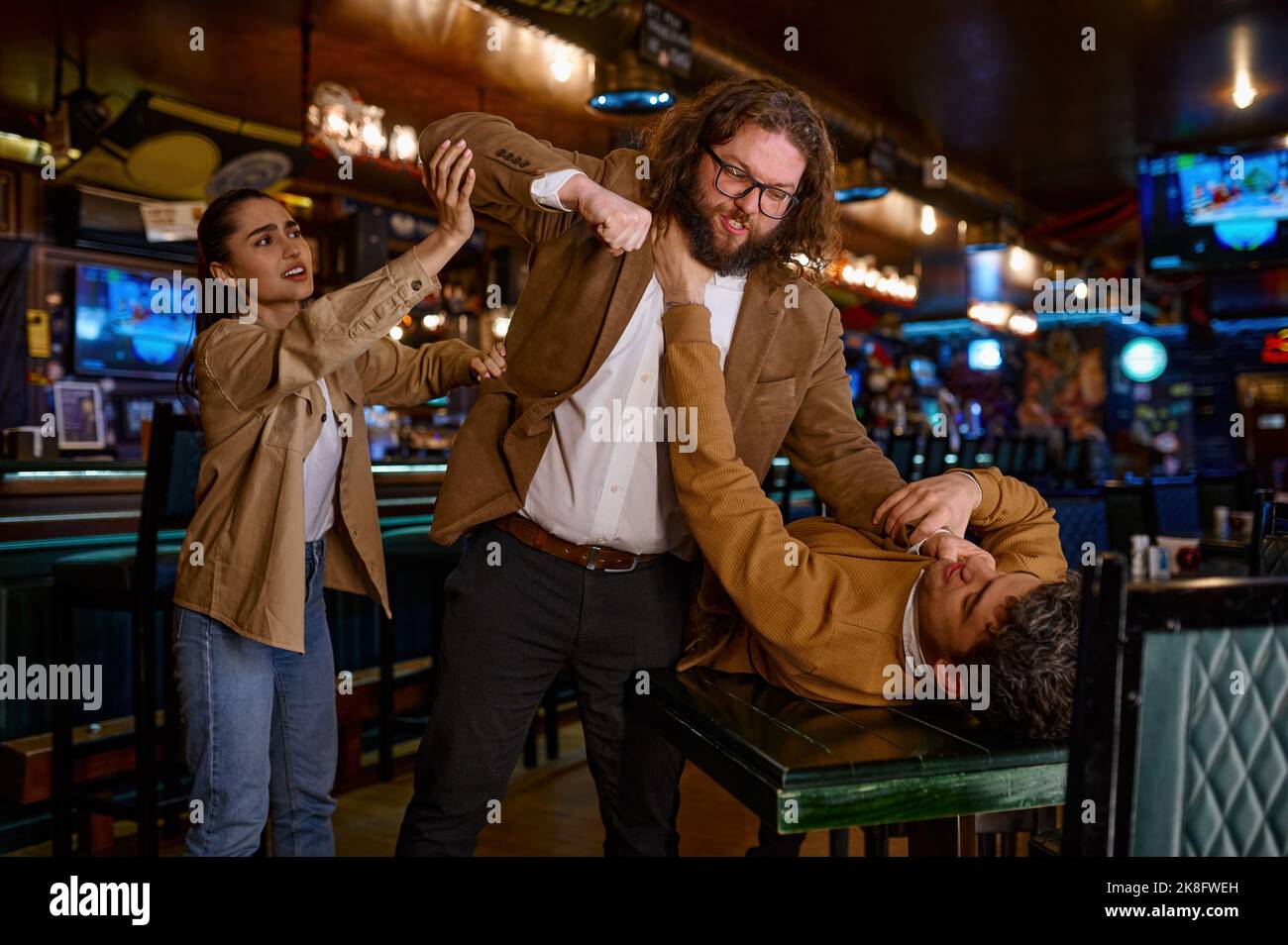 Young woman trying to separate craze mad fighting friends Stock Photo ...