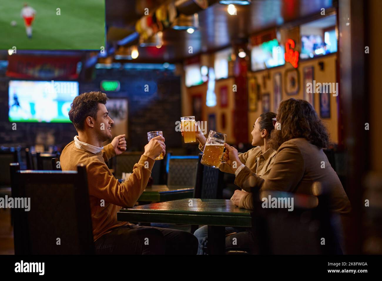 Happy football fans cheering drinking beer and watching soccer match ...