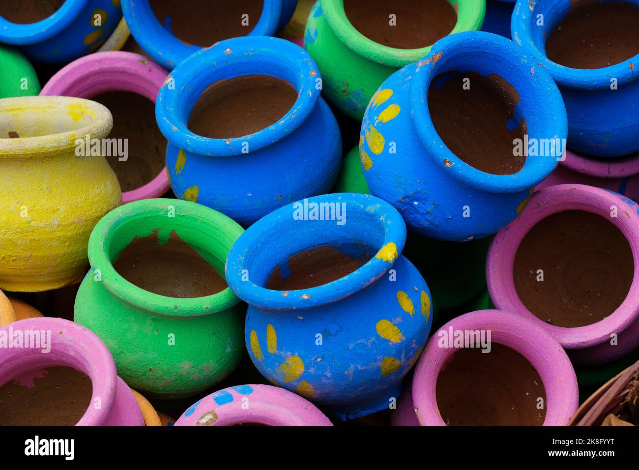 Artisan painting earthen pots, A background of colorful pots used for ...