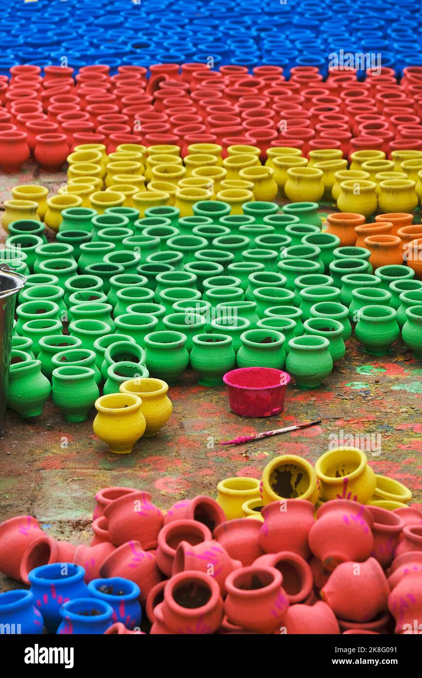 Artisan painting earthen pots, A background of colorful pots used for ...