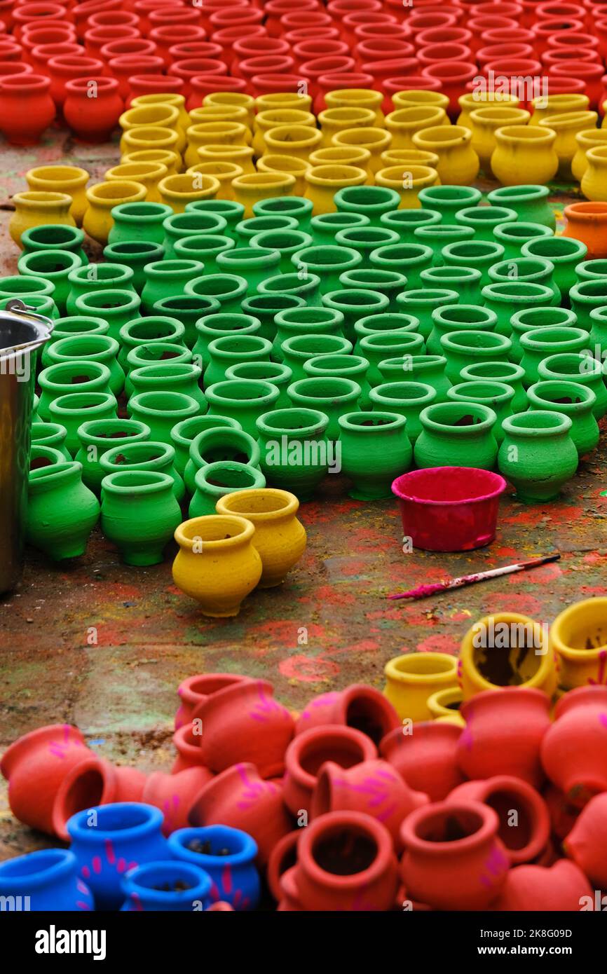 Artisan painting earthen pots, A background of colorful pots used for ...