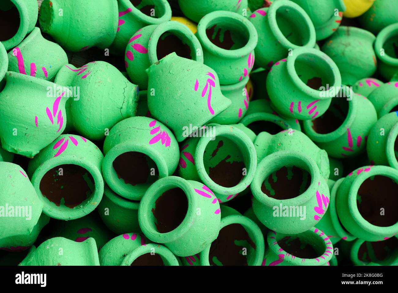 Artisan painting earthen pots, A background of colorful pots used for ...