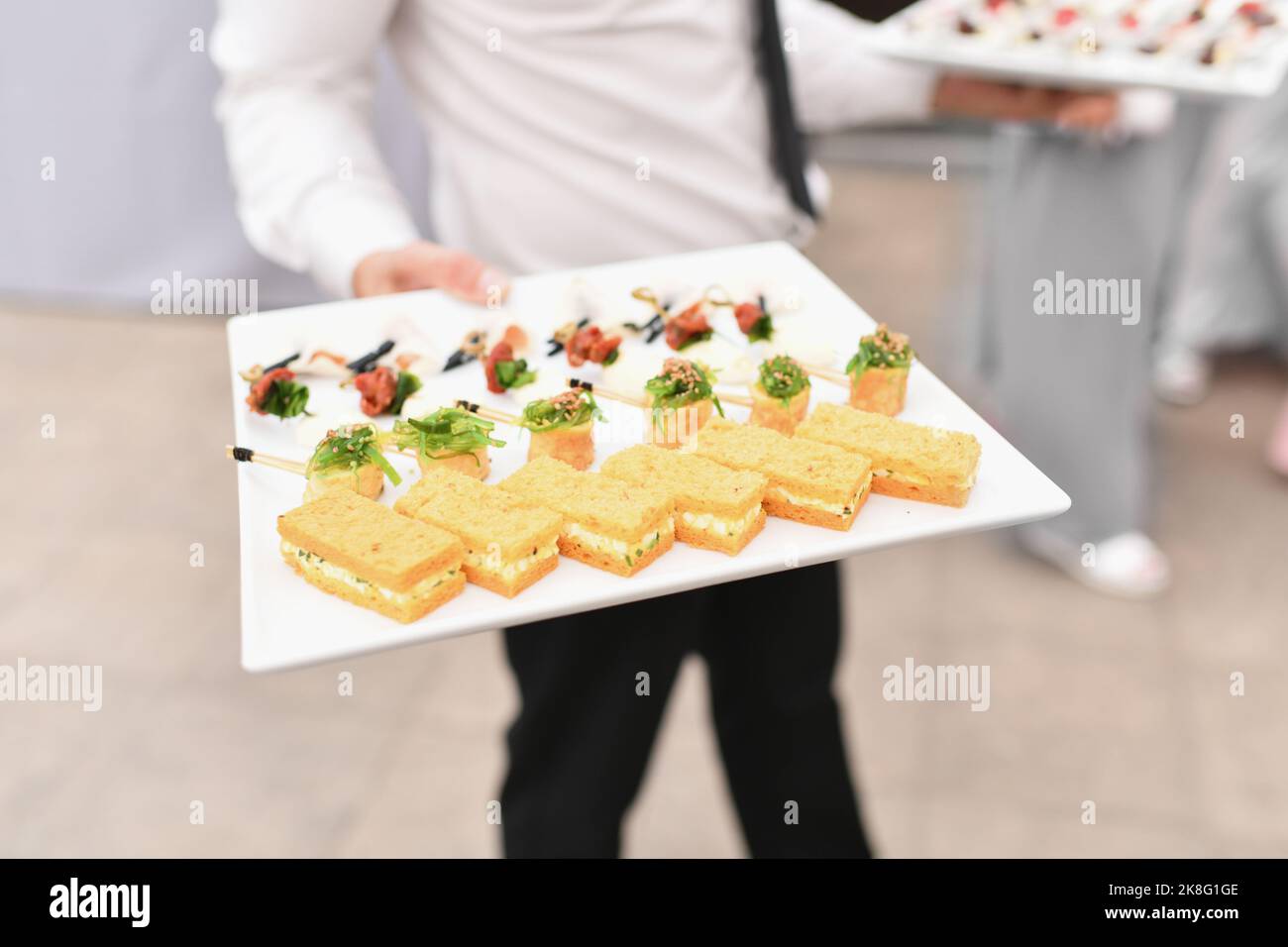 Waiter serving small appetizers at a wedding Stock Photo - Alamy