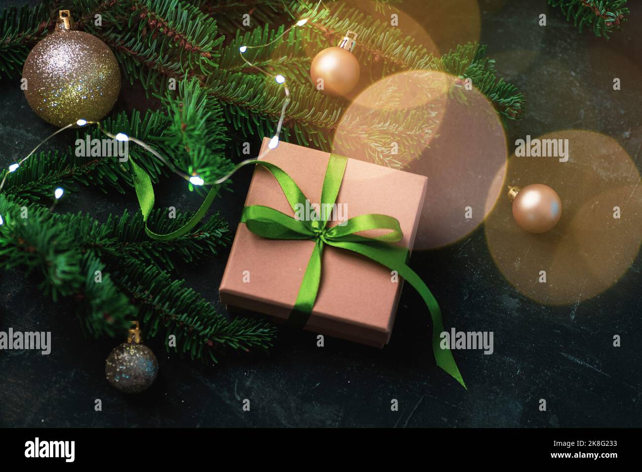 Gift box, Christmas baubles, fir tree and Christmas lights on black ...
