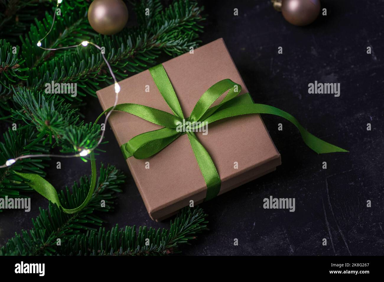 Gift box, Christmas baubles, fir tree and Christmas lights on black ...