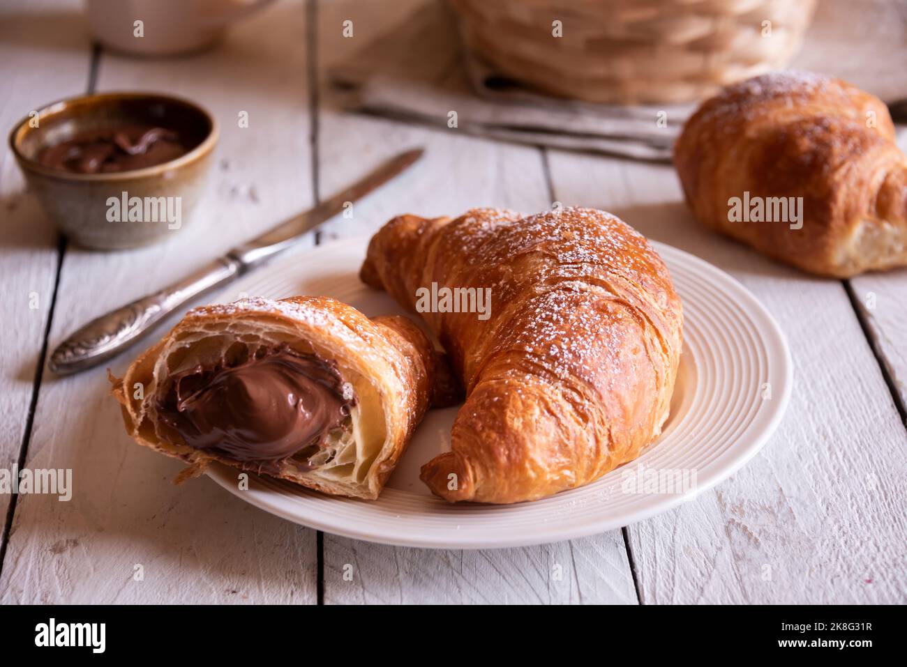 Delicious sweet croissant with chocolate on white wooden table Stock ...