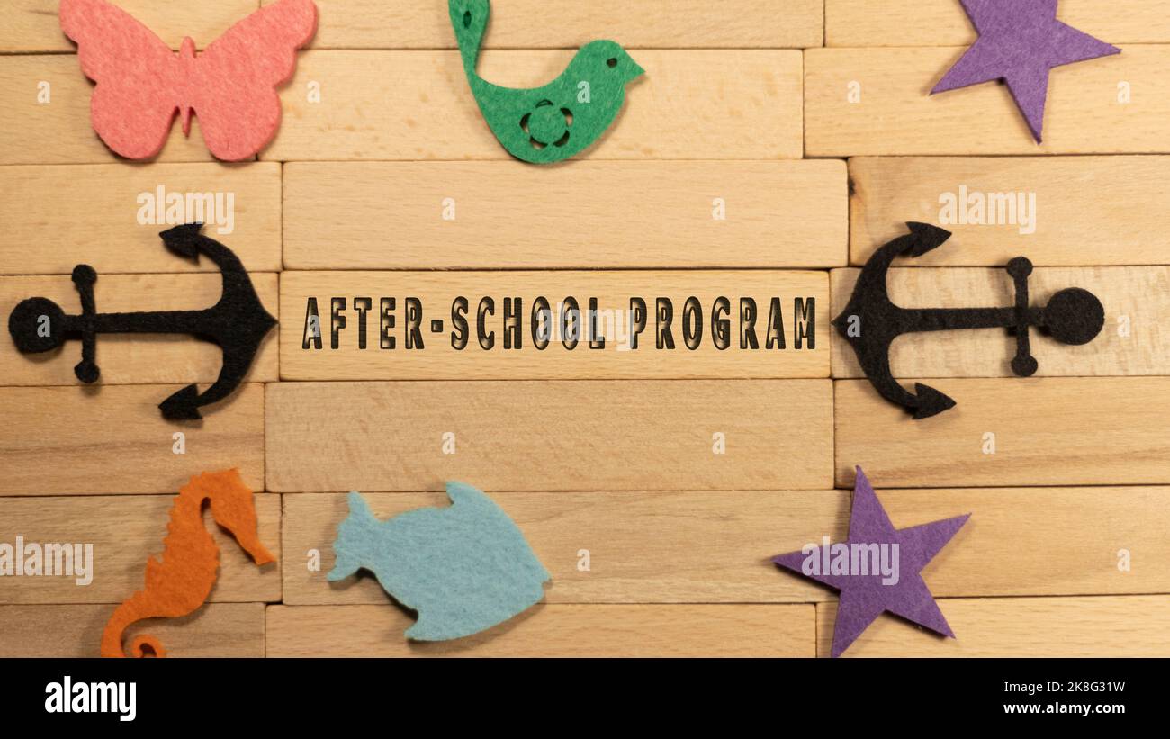 Wooden man holding frame. After school program writing. Background is ...