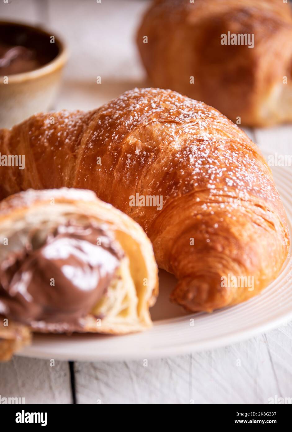Delicious sweet croissant with chocolate on white wooden table Stock ...