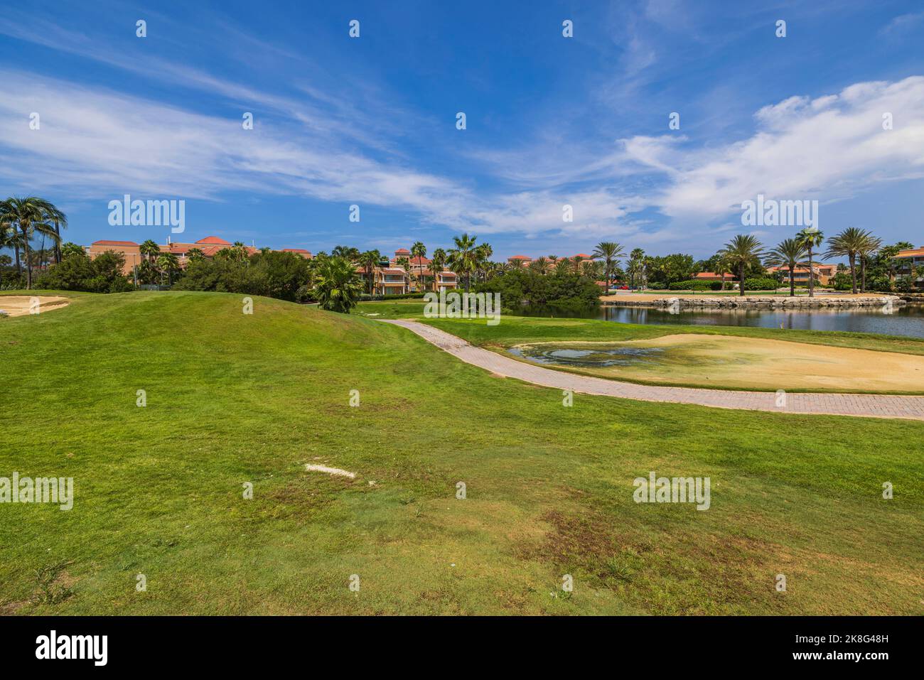 Beautiful view of Aruba's hotel golf course. Green grass and pink ...