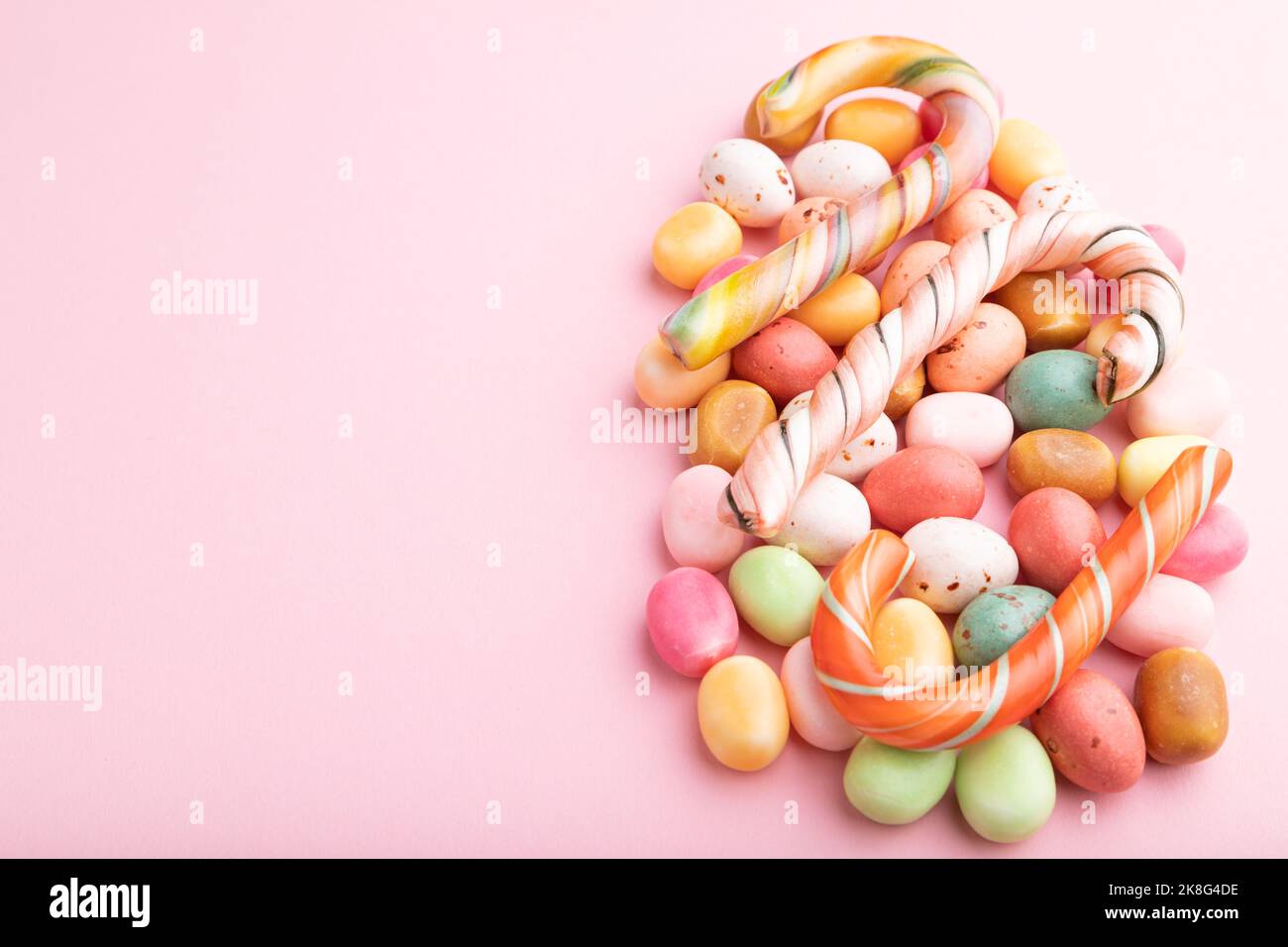 Various caramel candies on pink pastel background. copy space, side ...