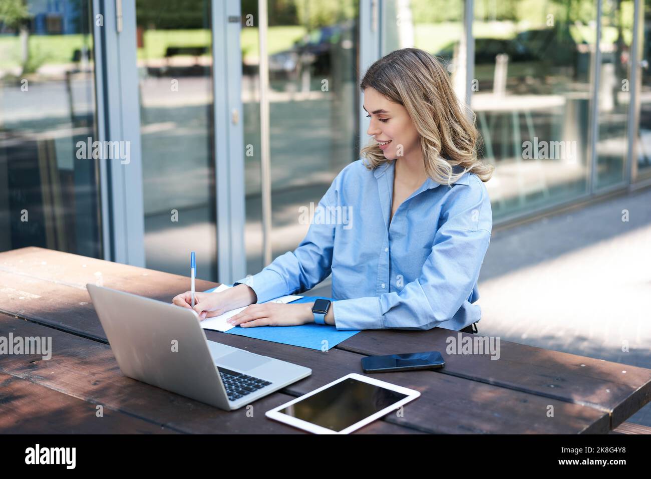 Portrait of beautiful young woman working on fresh air outside ...