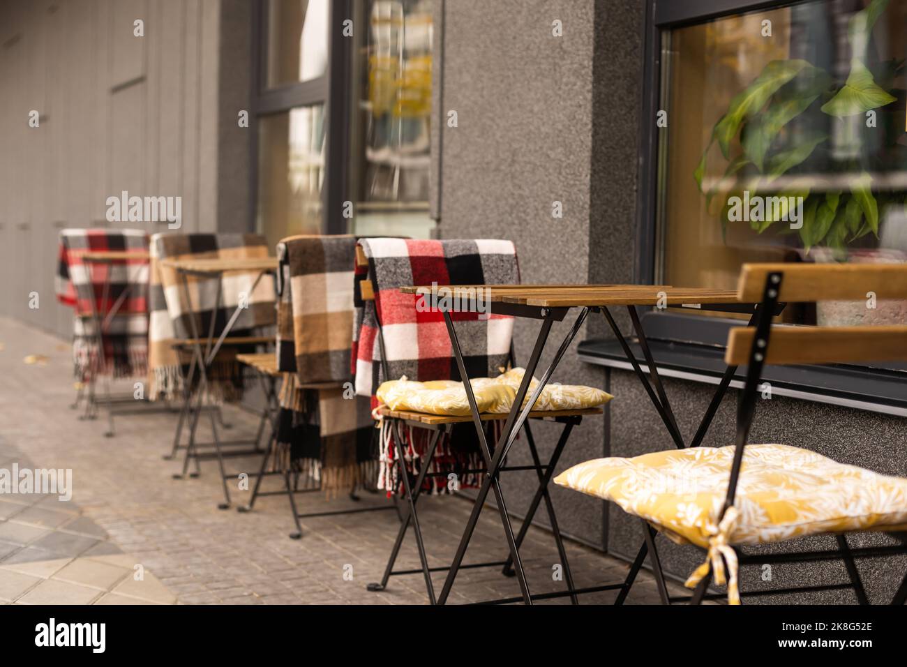 comfy seats in a street cafe with blankets Stock Photo - Alamy