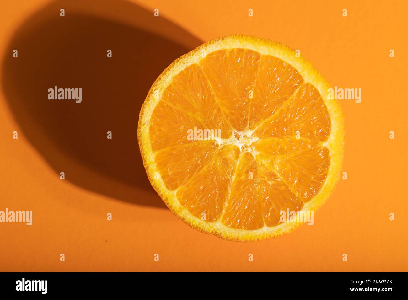 Ripe cut orange on orange pastel background. Top view, flat lay, close ...