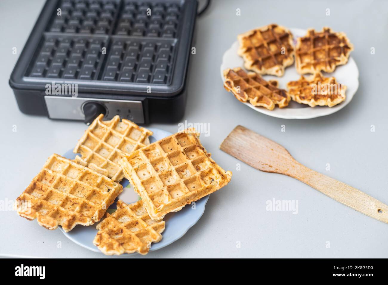 Modern waffle maker with ingredients on grey table Stock Photo - Alamy