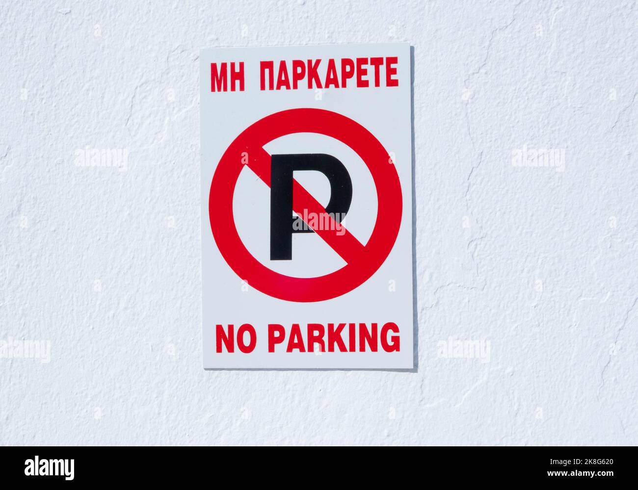 No parking sign in Greek and English languages on a white wall Stock ...
