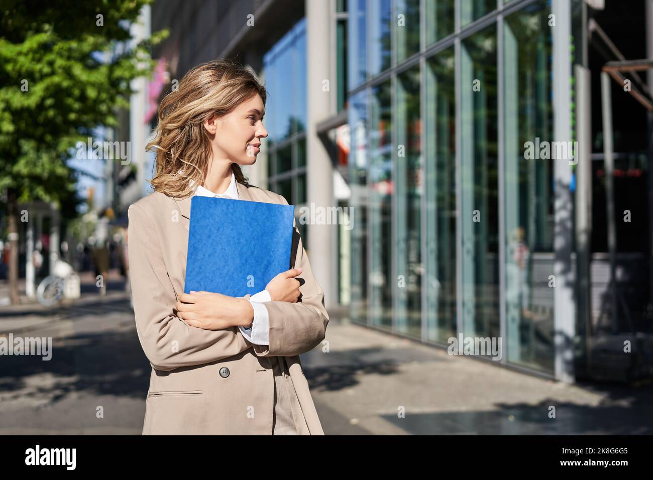 Portrait of businesswoman in beige suit and high heels walking on ...