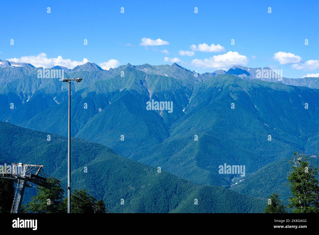 Misty mountains with snowy tops at resort against blue sky Stock Photo ...