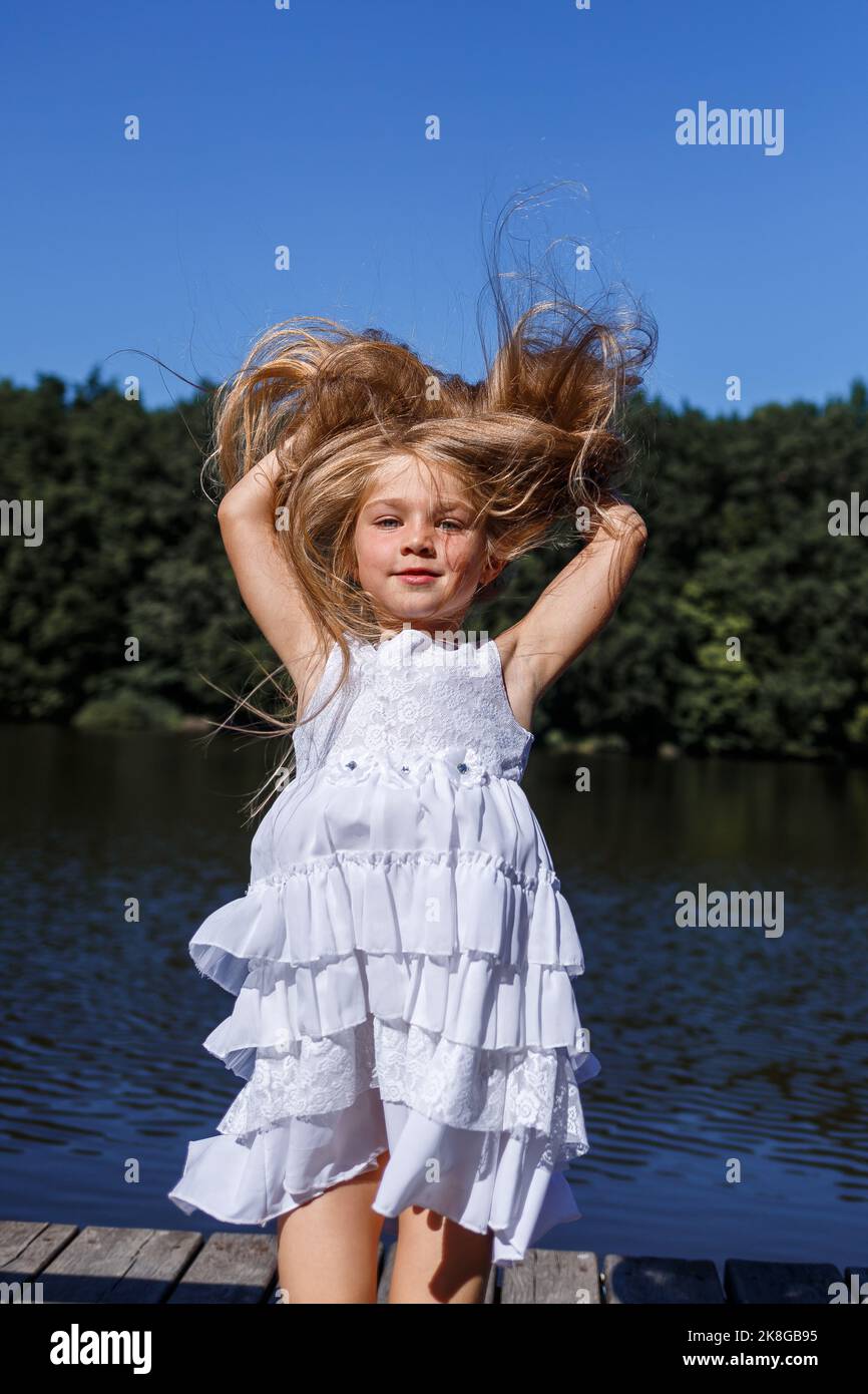 A Six Year Old Girl Is Wearing A White Dress Beautiful Long Hair Walk
