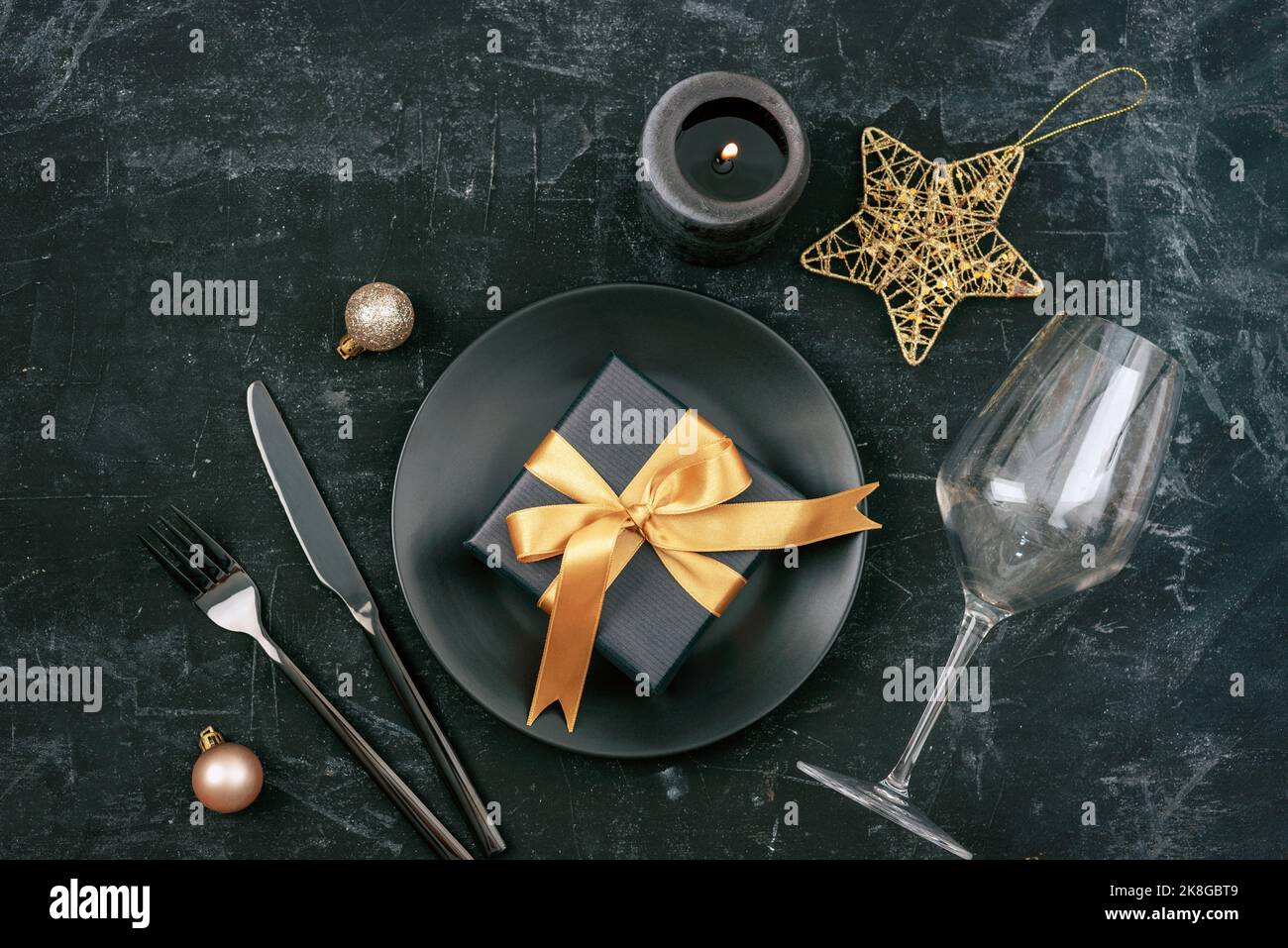 Stylish table setting, gift box, star and balls with black plate ...