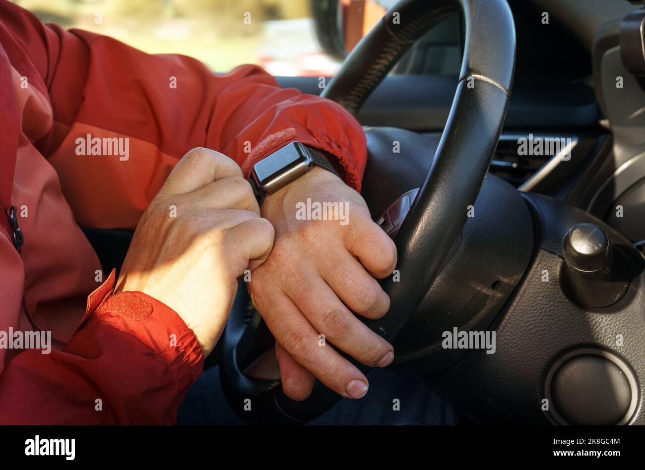 Driver man looks at his watch while driving. Close-up. Transport ...