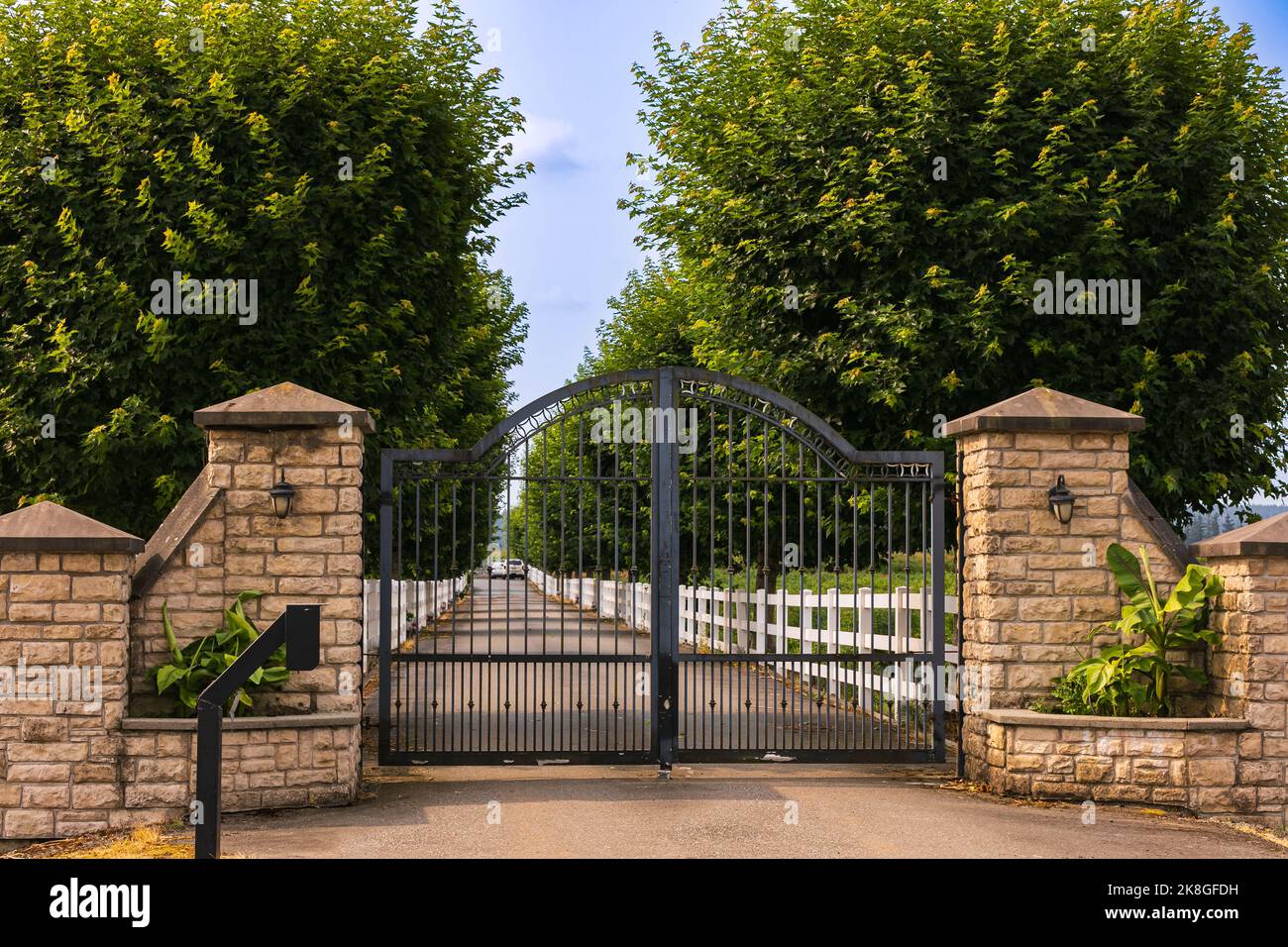 Iron front gate of a beautiful luxury home. Fancy large mansion behind ...