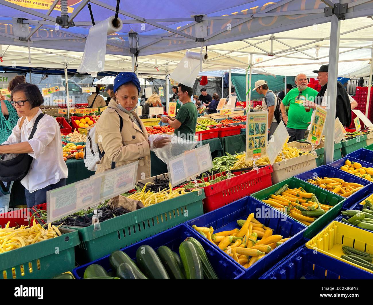 People shop for fresh vegetables in the early autumn at the Grand Army ...