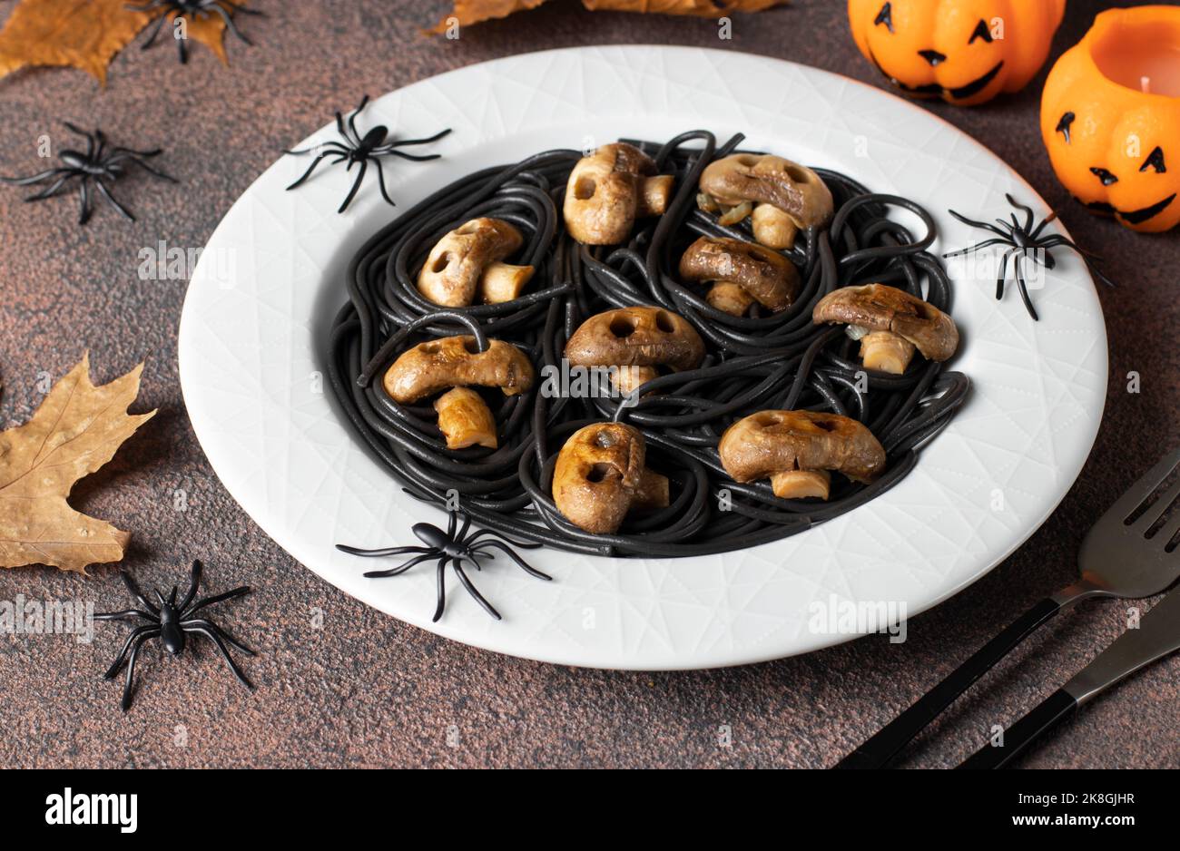 Black spaghetti and mushrooms in form of skulls, idea of cooking ...