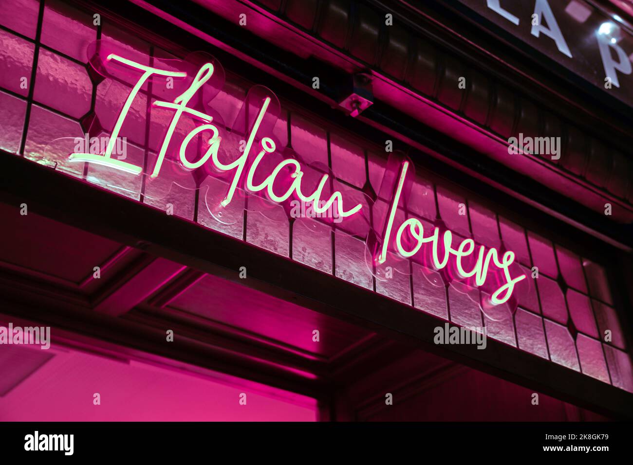 From below of bright pink glowing signboard in neon illumination ...