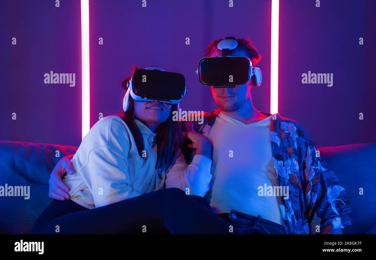 Multiracial unrecognizable couple in VR goggles sitting together on ...