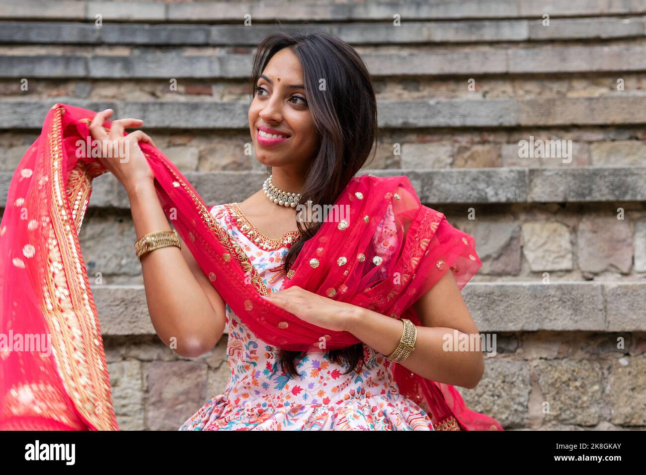 Happy young Indian female in traditional sari outfit smiling and ...