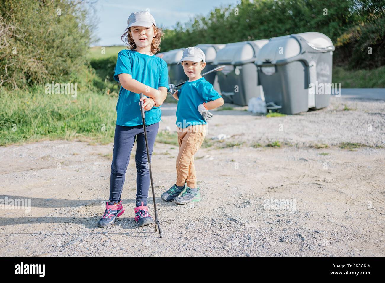 Full body of adorable little volunteers in uniforms holding reach ...