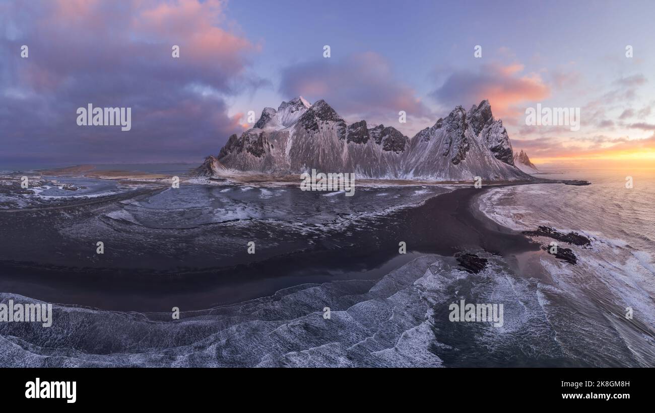 Drone view of calm frozen endless sea surrounding high rocky snowy ...