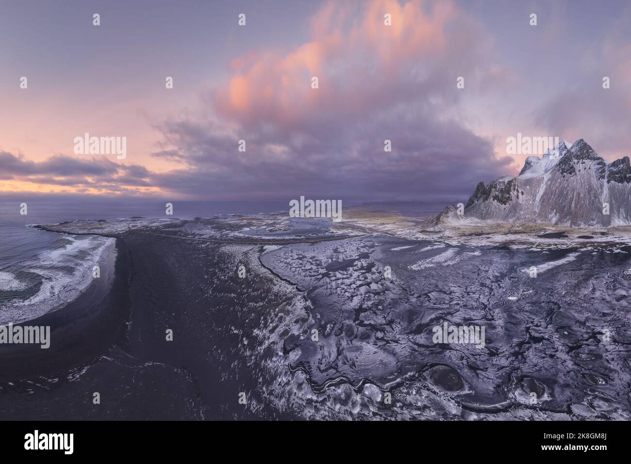 Drone view of calm frozen endless sea surrounding high rocky snowy ...