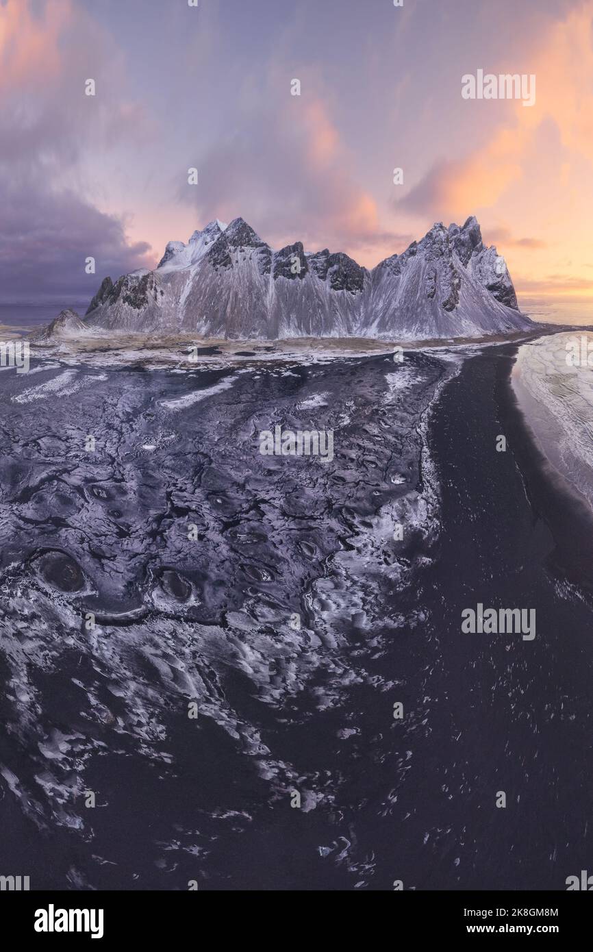 Drone view of calm frozen endless sea surrounding high rocky snowy ...