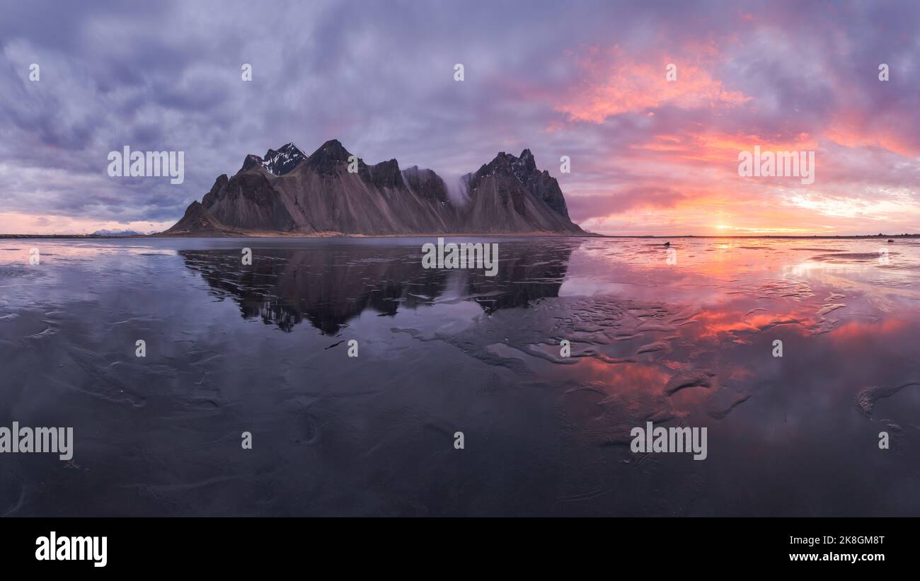 Spectacular Nordic scenery of calm frozen lake near rocky Vestrahorn ...