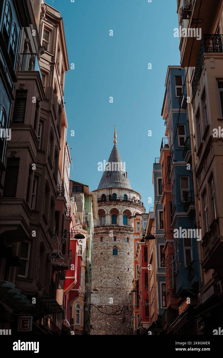 From below famous Galata Tower located behind houses in end of narrow ...