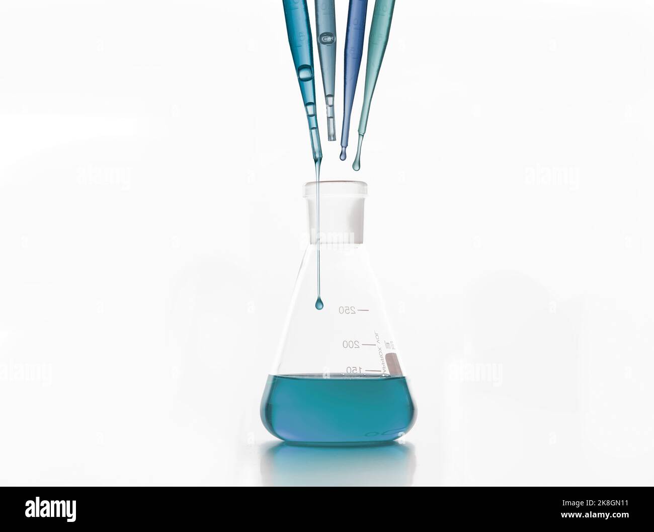 Test droppers with blue liquids over glass laboratory flask placed on ...