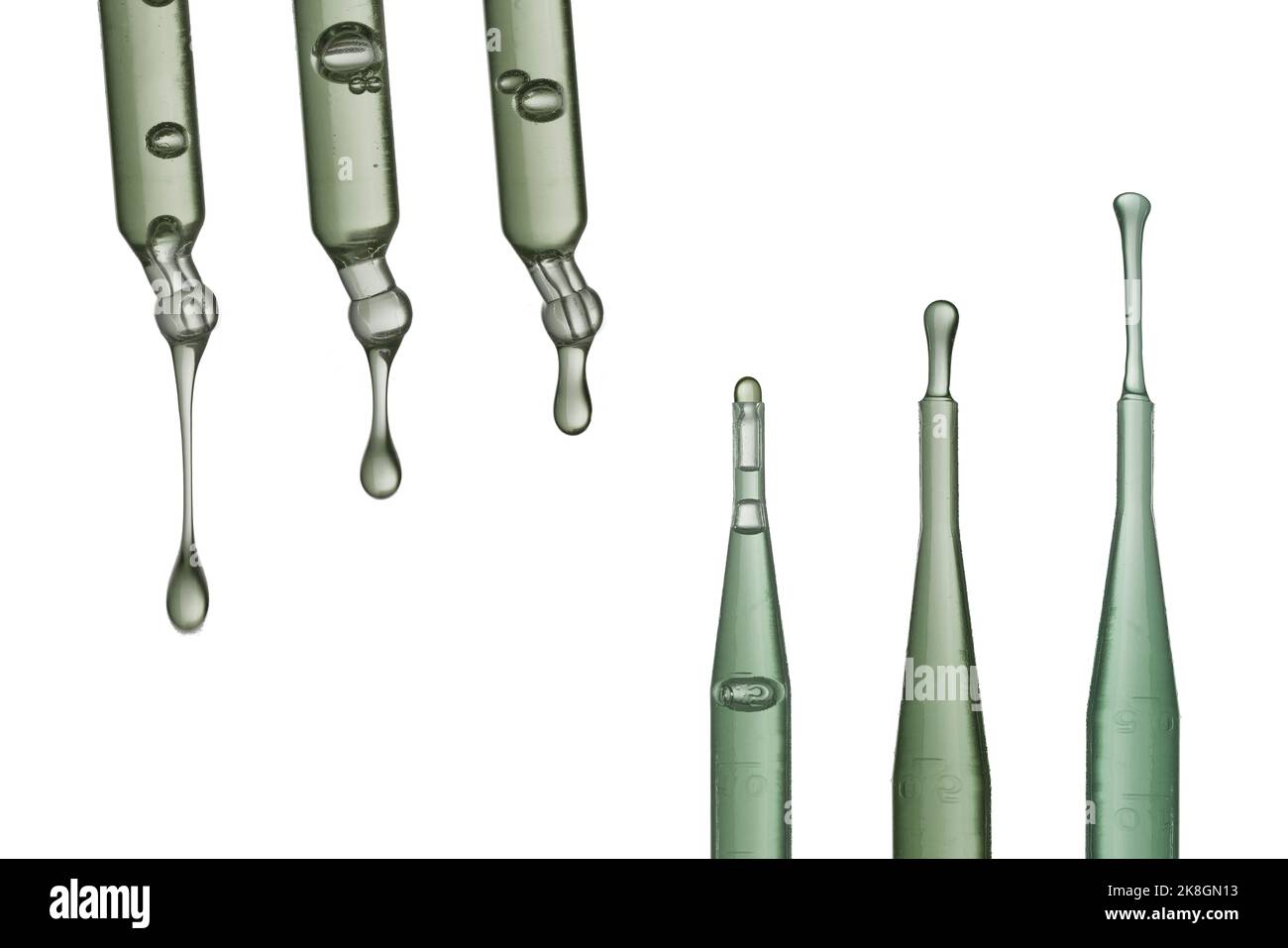 Glass laboratory pipettes with gray substance against white background ...