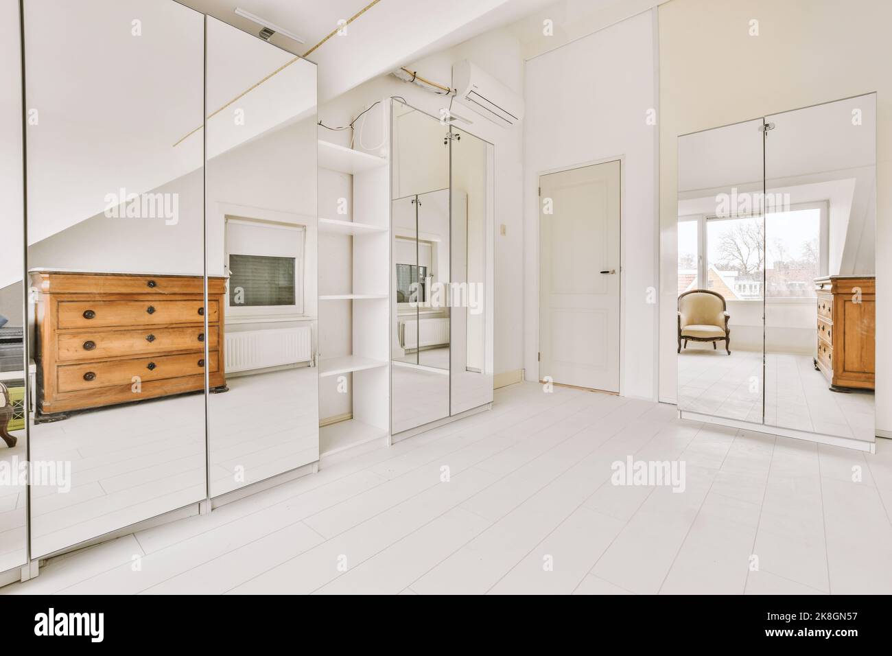 Modern cupboard and vintage chest placed near doors and wicker basket ...