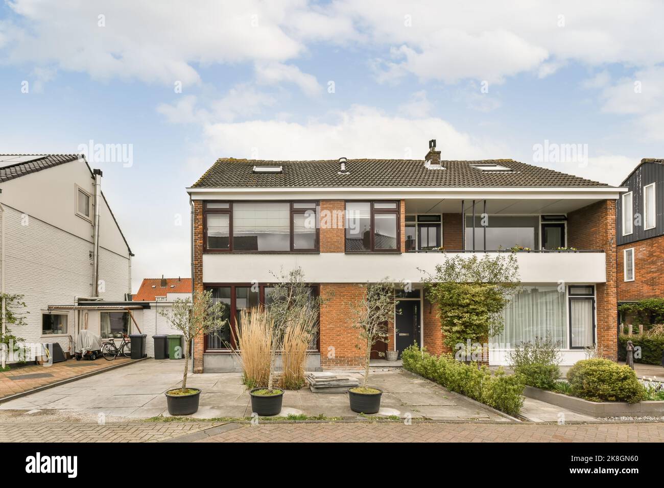 View of a street with houses lined up under a blue sky with clouds ...