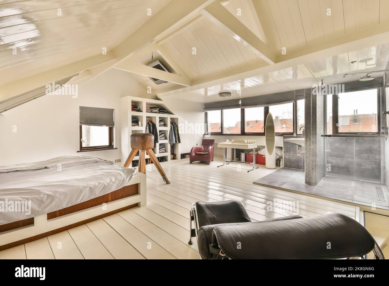 Comfortable bed next to a bright window and wooden floor Stock Photo ...