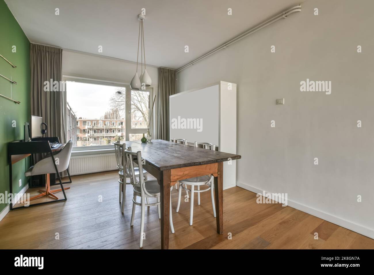 big wooden table with chairs near desk with computer close to window in ...